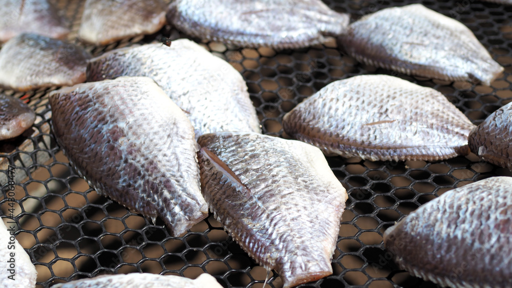Preservation tilapia fish with sunbathe, dried and cutting head to ...