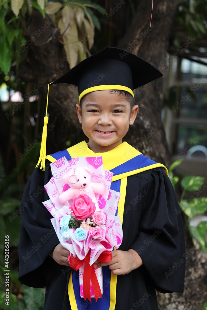 cute asian boy Kindergarten graduates, wearing gowns or little black ...