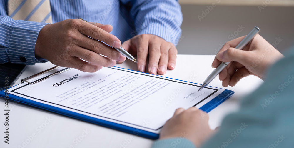 Businesswoman signing a document or application form in a folder ...