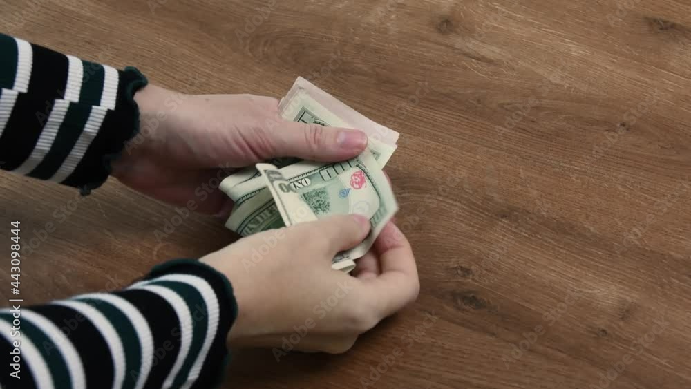 Hands count dollar bills and found rejected dollar bills. Woman holds ...