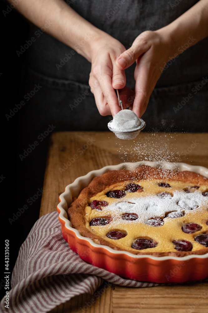 Crop cook adding powdered sugar on cherry clafoutis Stock Photo | Adobe ...