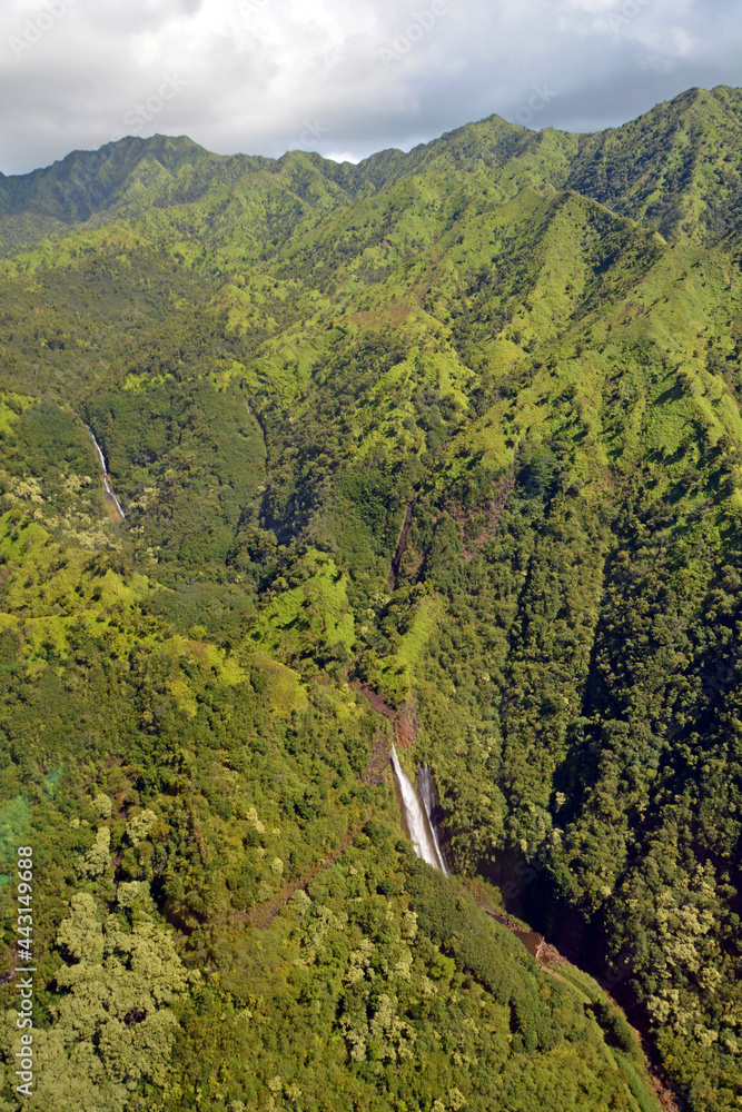 mana waiopuna falls and mountains in a lush rain forest, as seen from a ...