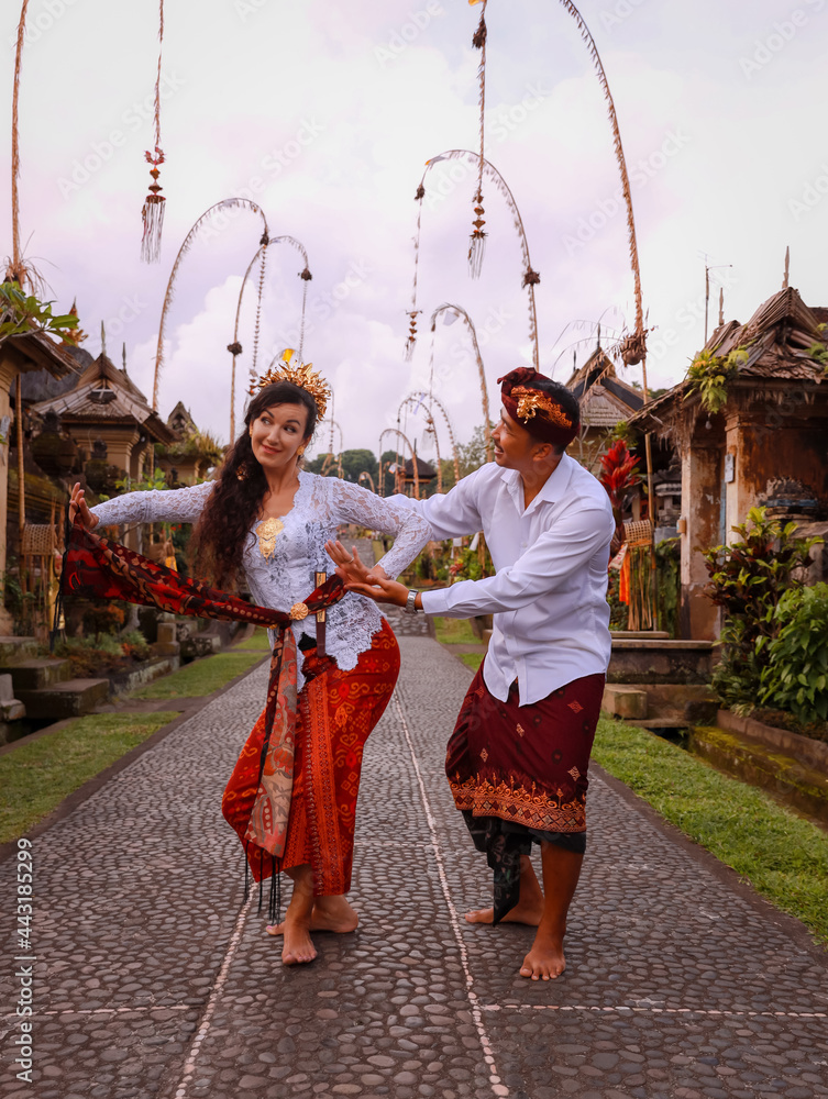 Multicultural couple dancing traditional Balinese dance. Happy couple spending time together ...