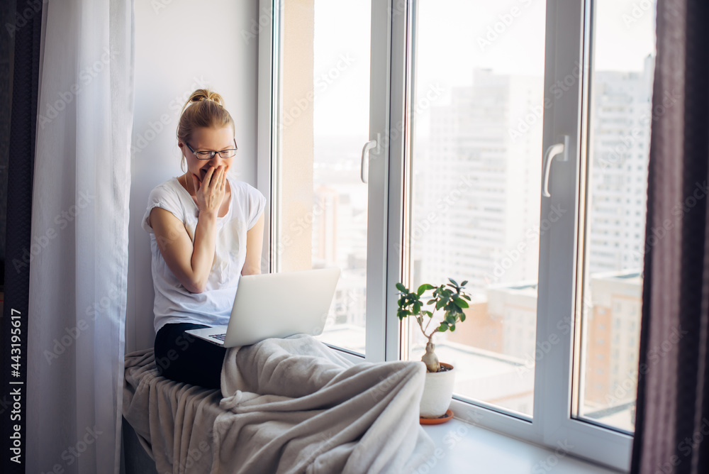 Happy young adult woman freelancer wearing glasses sitting on window ...