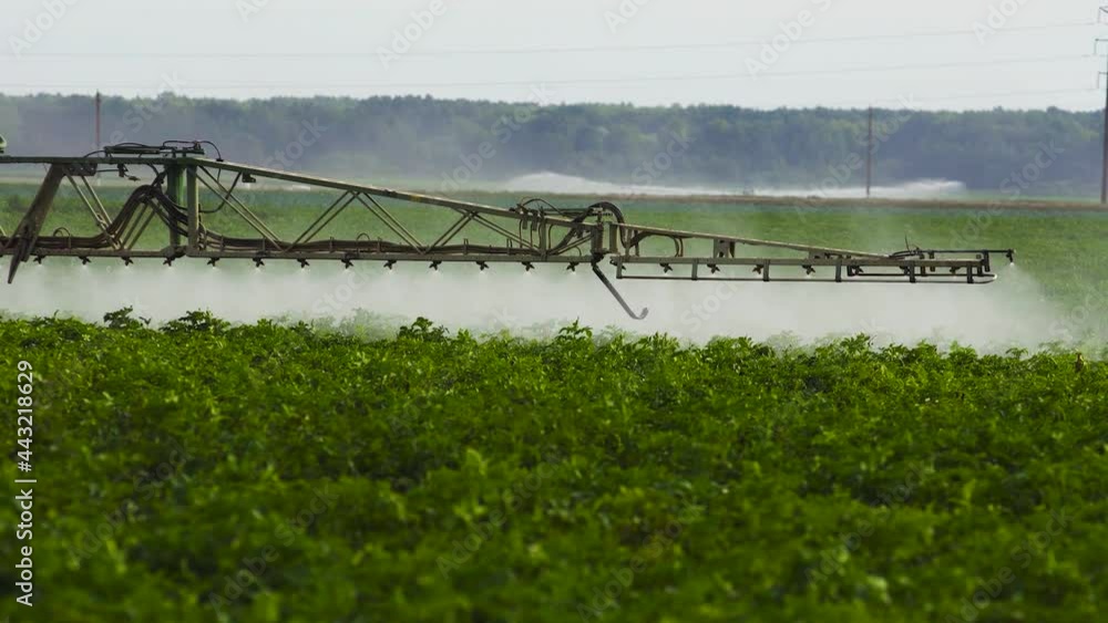 Tractor spraying glyphosate pesticides on farm field from above.Tractor ...