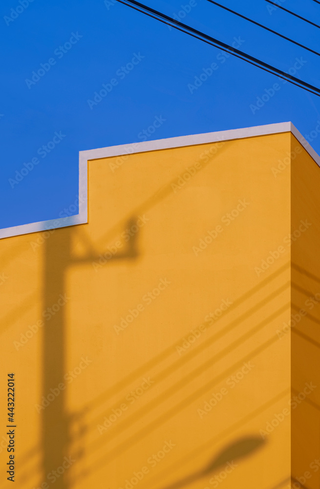 Shadow of electric pole on surface of yellow building wall with power ...