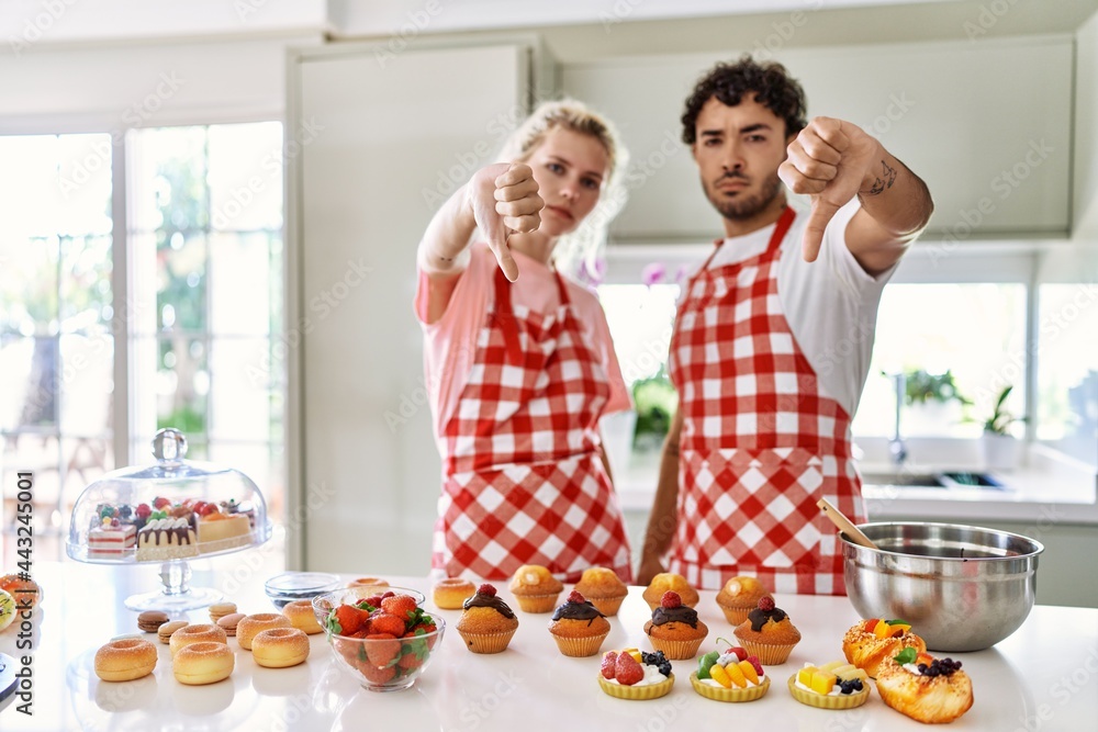 Couple of wife and husband cooking pastries at the kitchen looking ...