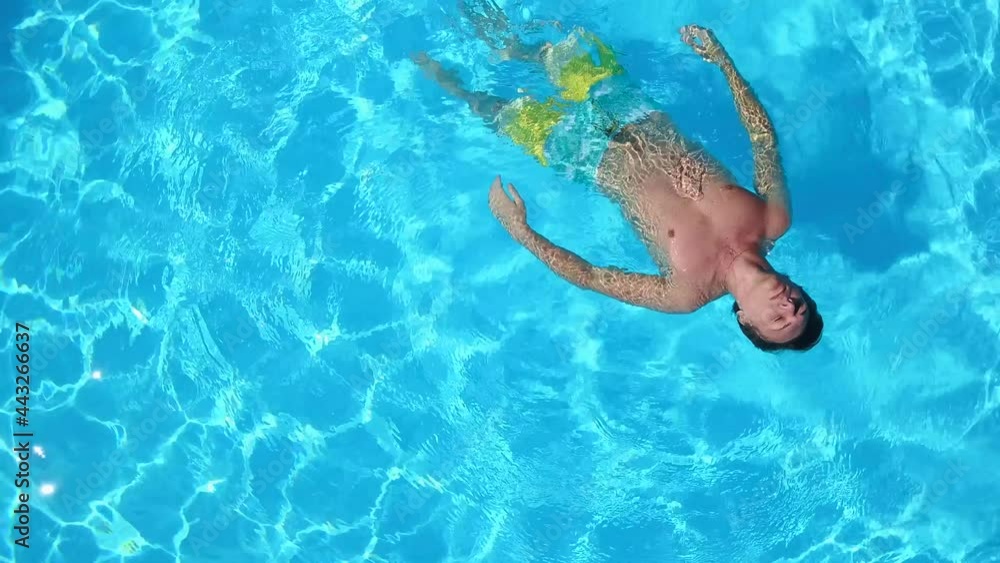 Aerial. Man swimming on her back in pool. Girl chilling on inflatable ...