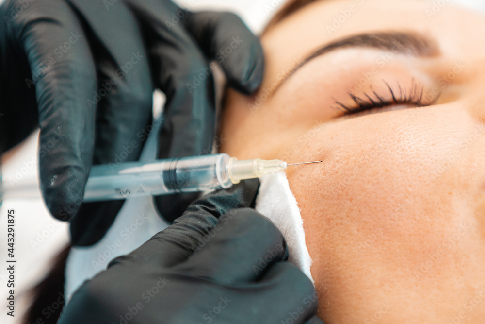 Plastic syrgery. Close-up of female face getting injection in the ...