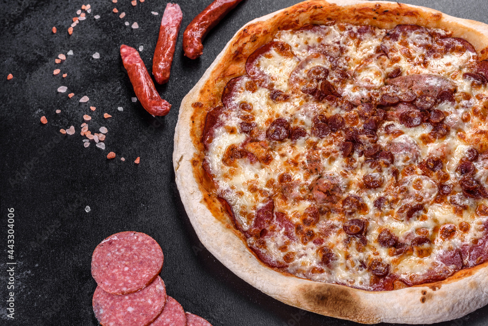 Fresh delicious Italian pizza with four types of meat on a dark ...