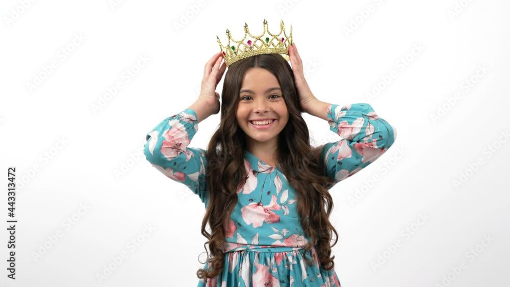 happy egocentric child in queen crown pointing thumb up on herself ...