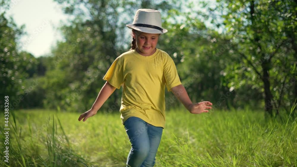 Happy girl. Little girl run through forest park. Kid plays on green ...
