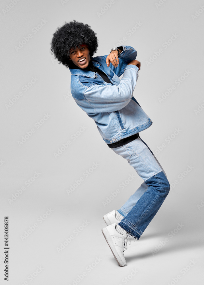 Foto de Young man enjoy of standing on tiptoe in stylish clothes do ...