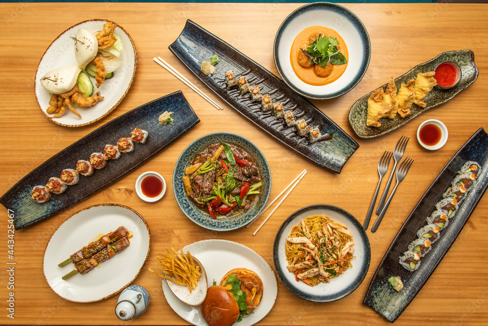Set of beautiful asian food dishes on wooden table. Uramaki, tempura ...