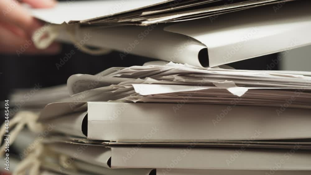 Stacking folders with documents in a stack with hands, counting files ...