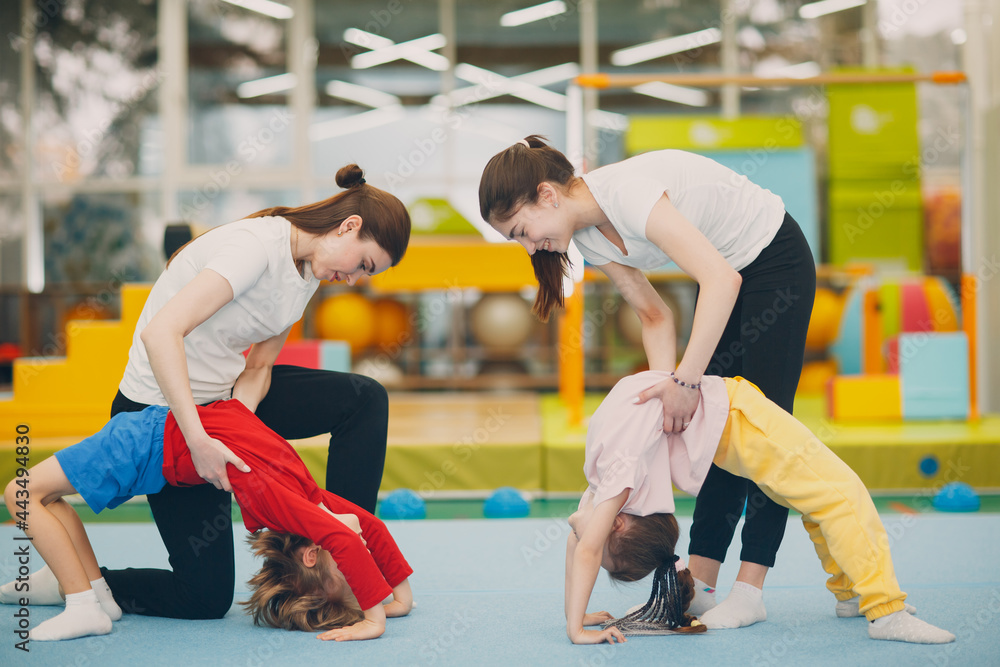 Kids doing exercise bridge in gym at kindergarten or elementary school ...