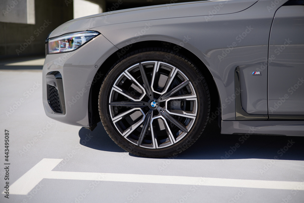 Wheel of a gray BMW 740D, parked in an empty parking lot.Side view. No ...