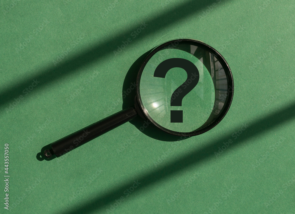 Magnifying glass with question mark inside on green background. Concept ...