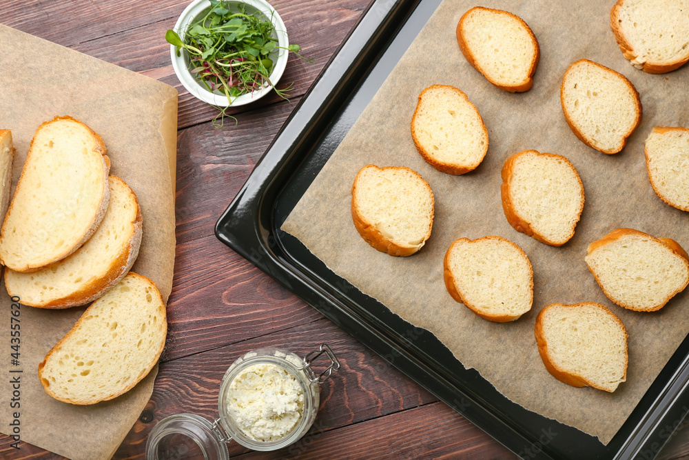 Baking sheet with slices of fresh bread on wooden background Stock ...