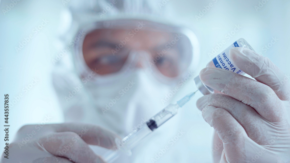 Closeup Doctor or Scientist in PPE suit in laboratory draw the vaccine ...