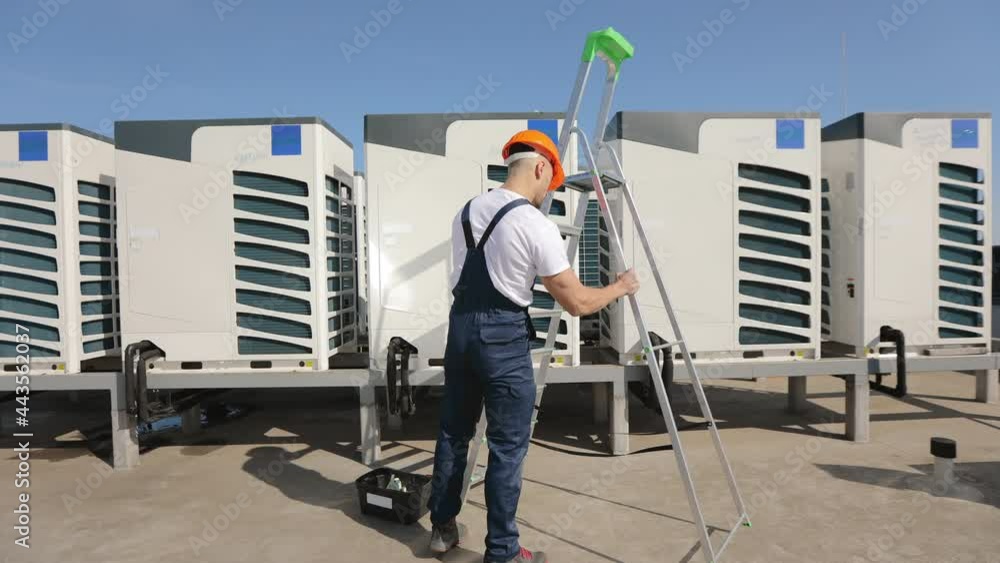 Video „The young engineer is laying out a ladder and climbing it up. He ...