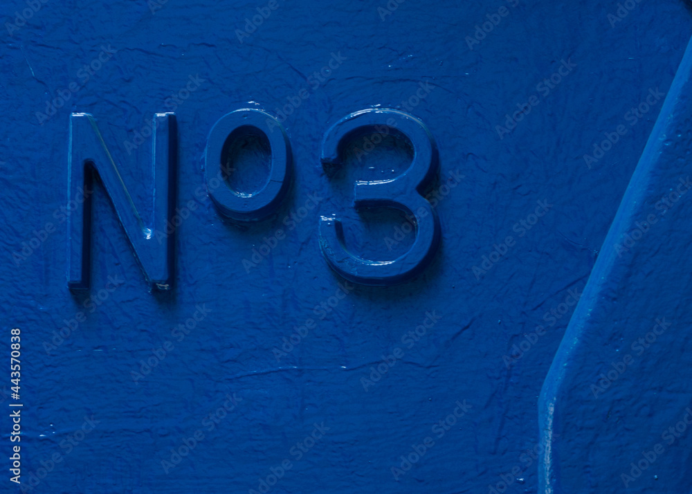 Number three No 3 blue and embossed in steel with shadows. Deep blue ...