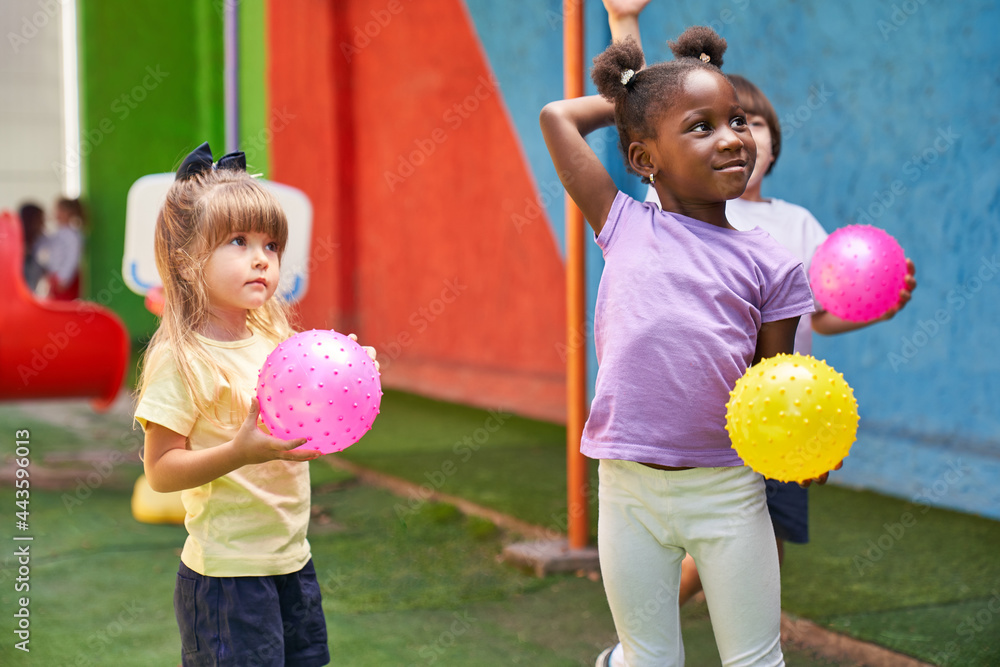 Gruppe multikultureller Kinder beim Ball spielen Stock Photo | Adobe Stock