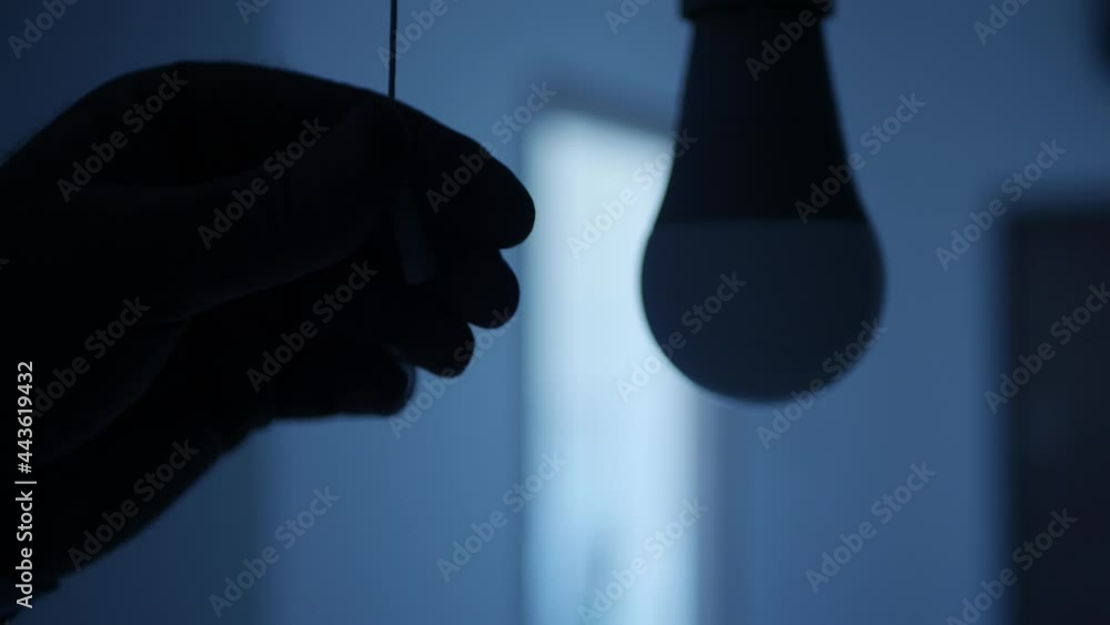 A Person Pulls the Switch Cord with His Hand and Turns Off the Light ...