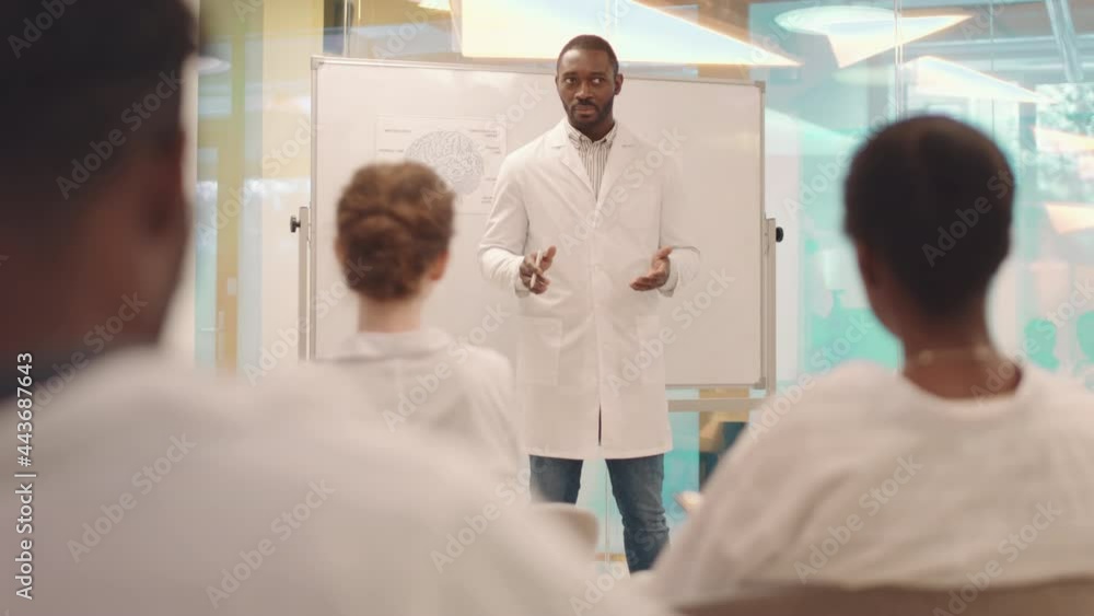 Medium shot of young Afro American university professor in jeans and ...