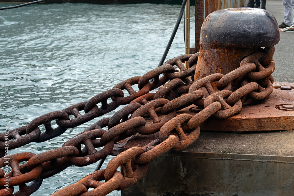 Stud link type rusty ship anchor chain and one headed mooring bitt on a ...