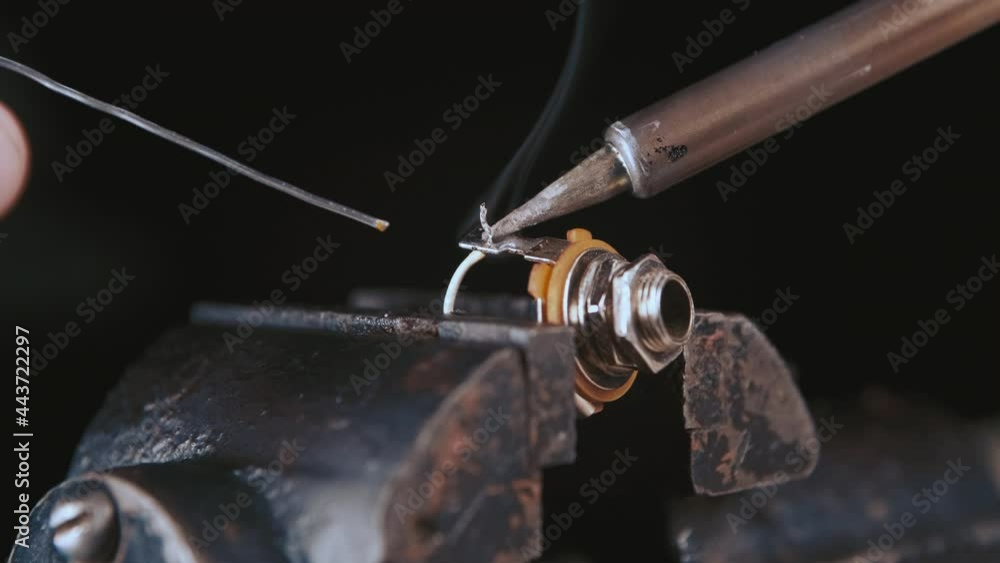 A repair guy is soldering electrical parts, wires and so on using ...