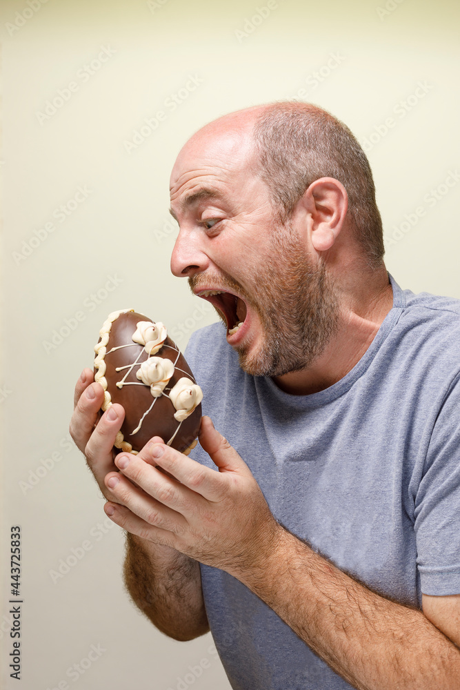 Man eating a chocolate candy. Expression of devouring a sweet. Opening ...