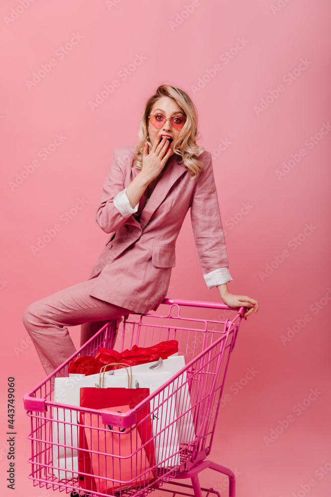 Fashionable model in stylish designer outfit sitting on trolley from ...
