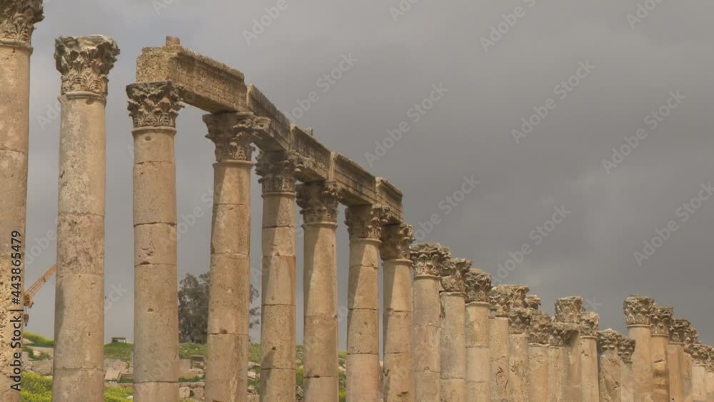 A wide still view of a series of tall ancient pillars located on ...