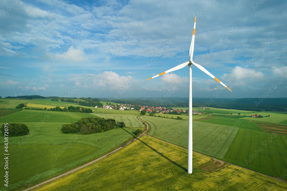 One wind turbine on an agricultural field. Narrow road leading to a ...