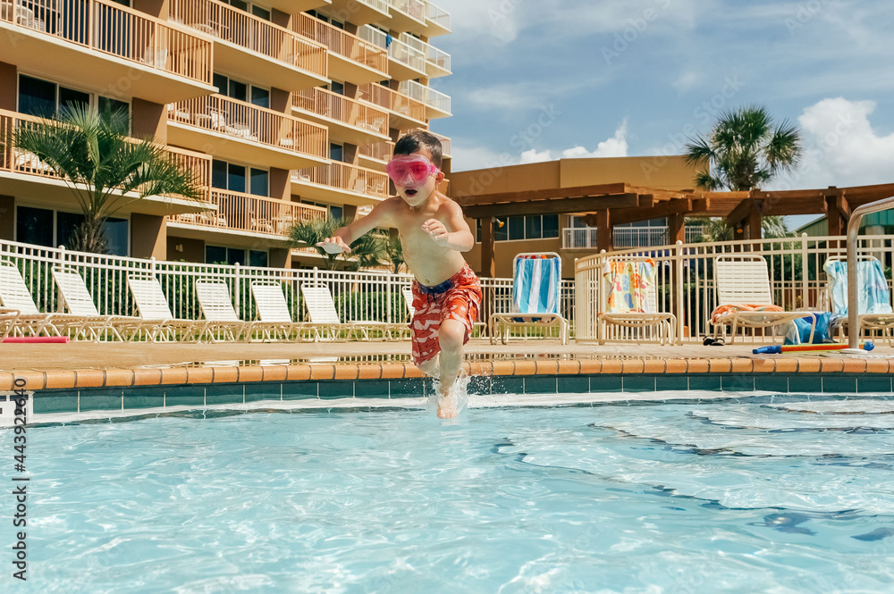 Child diving into a refreshing swimming pool. Stock Photo | Adobe Stock