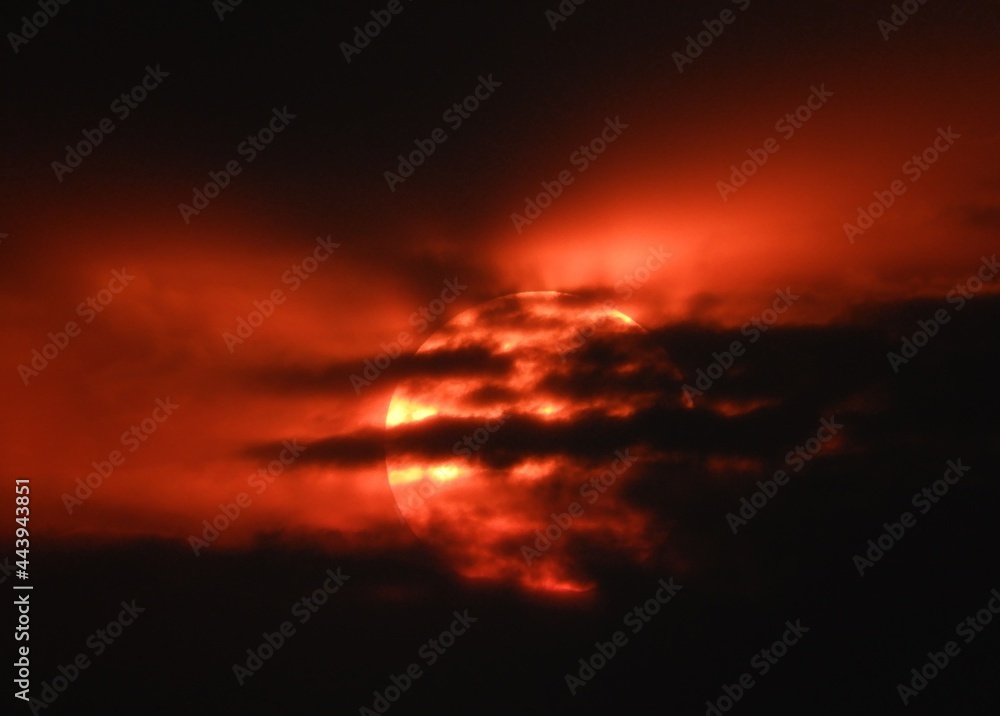 an eerie view of the sun as it sets through the smoke from the western ...