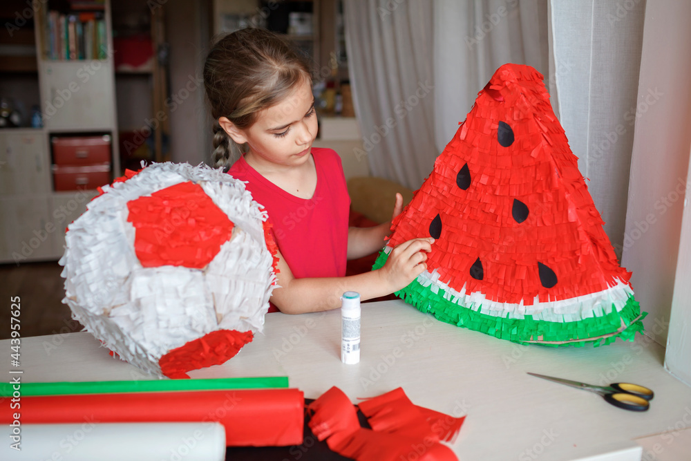 Preteen girl doing pinata with cardboard from used box and color crepe ...