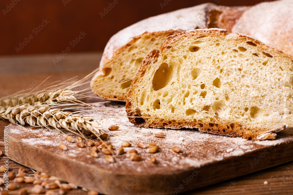 seen up close, slices of rustic white bread with ear and grains of ...
