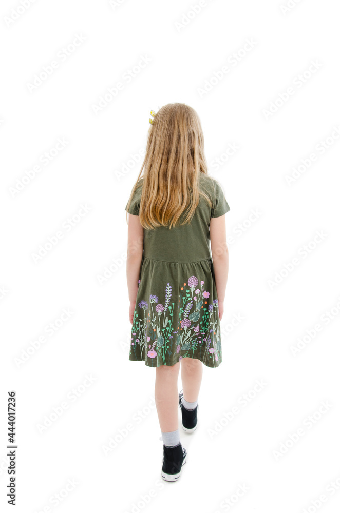 Back view of walking young girl. Beautiful little girl in motion ...