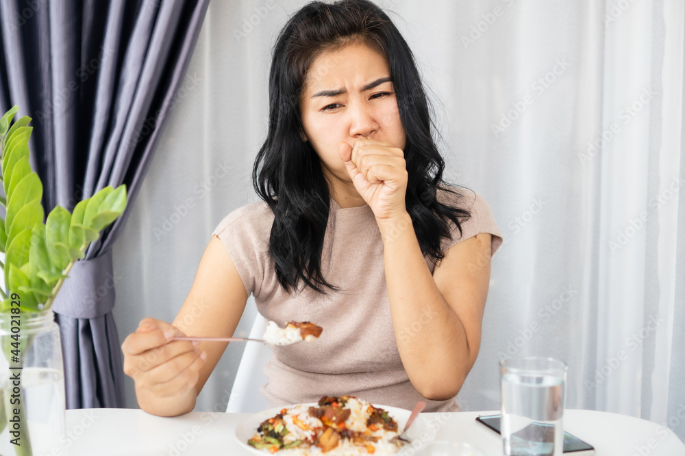 Asian woman choking while eating a meal she has food stuck in the ...
