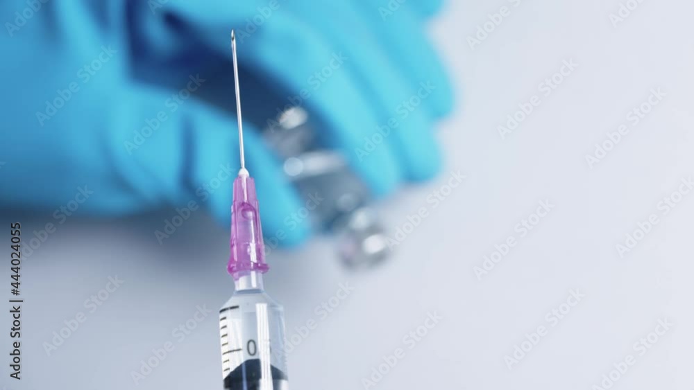 Close up shot of a transparent liquid vaccines being vertical pouring ...