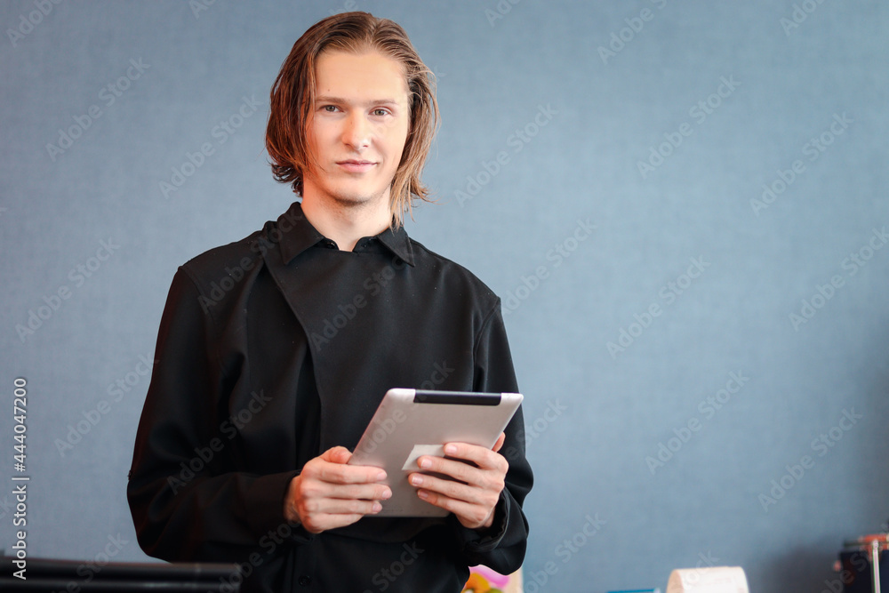 Young handsome male staff waiter in black uniform talking order on ...