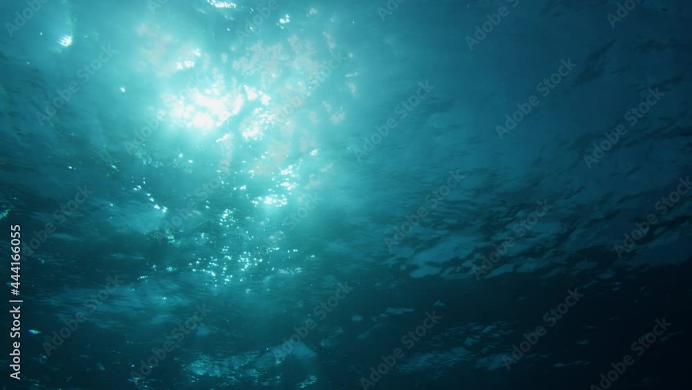 Stockvideo Sunbeams penetrating wavy ocean surface. Ocean background ...