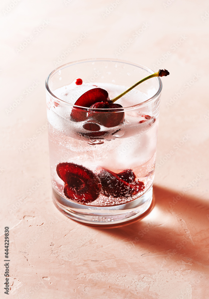 Glass of Summer cocktail with gin and cold tonic, decorated with halved ...