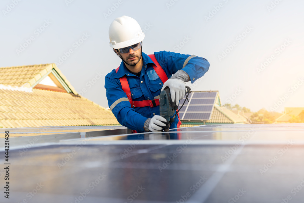 A worker wearing fall protection safety equipment while installing the ...