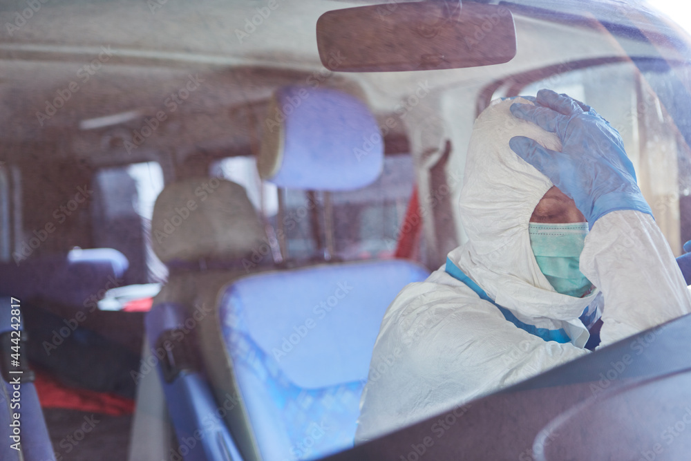 Exhausted paramedic from the emergency services takes a break in the ...