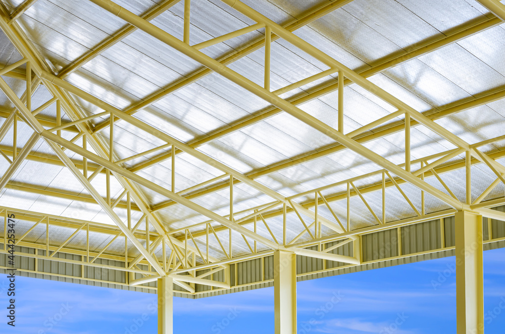 Low angle and perspective side view of yellow metal building roof ...