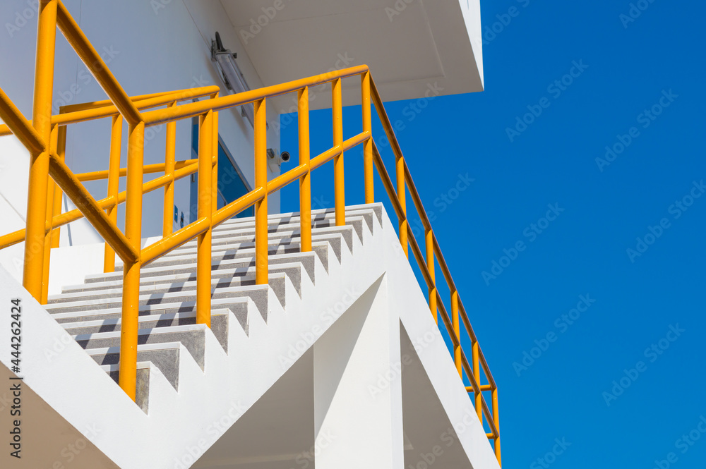 The handrail yellow stair for fire escape with the steel wall of the ...