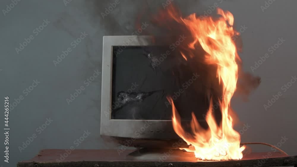 The computer monitor is on fire, the fire spreads over the computer ...
